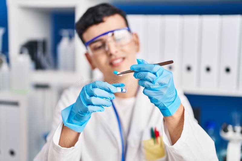 Young Non Binary Man Scientist Smiling Confident Holding Pills at ...