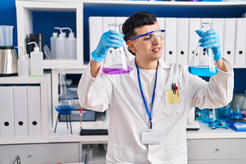 Young Non Binary Man Scientist Smiling Confident Measuring Liquid at ...