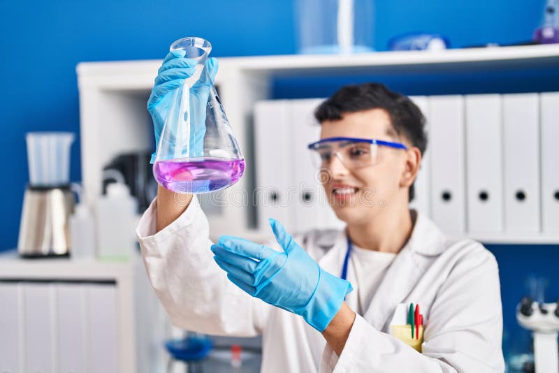 Young Non Binary Man Scientist Smiling Confident Measuring Liquid at ...