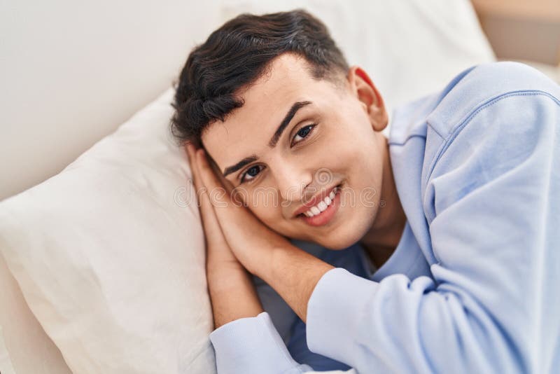Young Non Binary Man Smiling Confident Lying on Bed Stock Image - Image ...