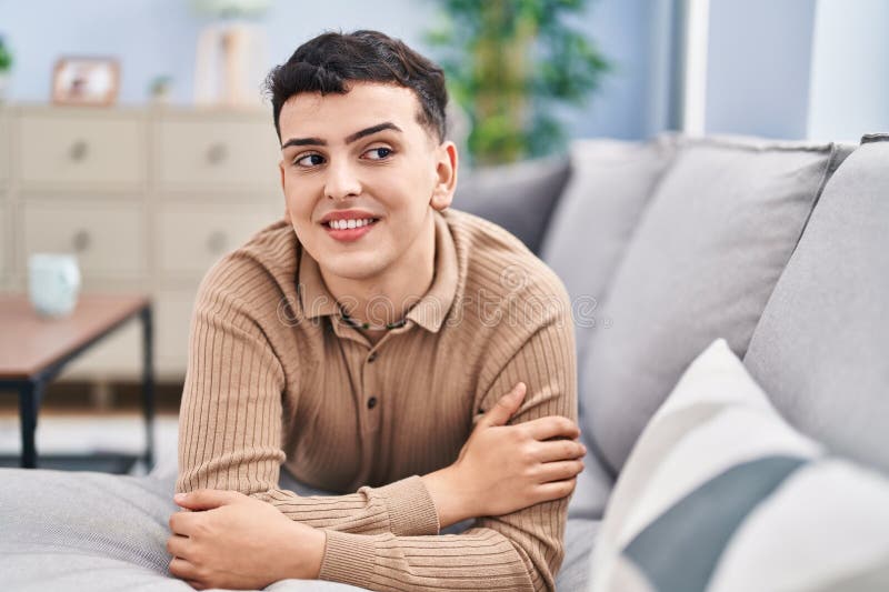 Young Non Binary Man Smiling Confident Lying on Sofa at Home Stock ...
