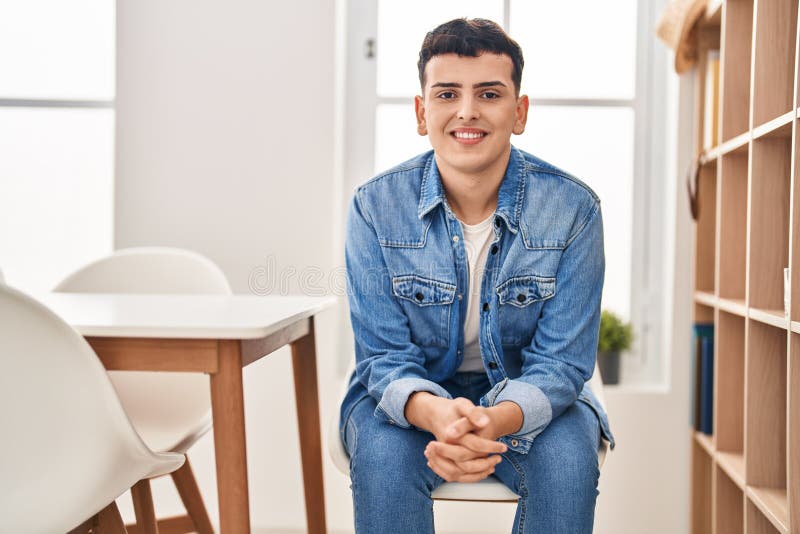 Young Non Binary Man Smiling Confident Sitting on Chair at Home Stock ...