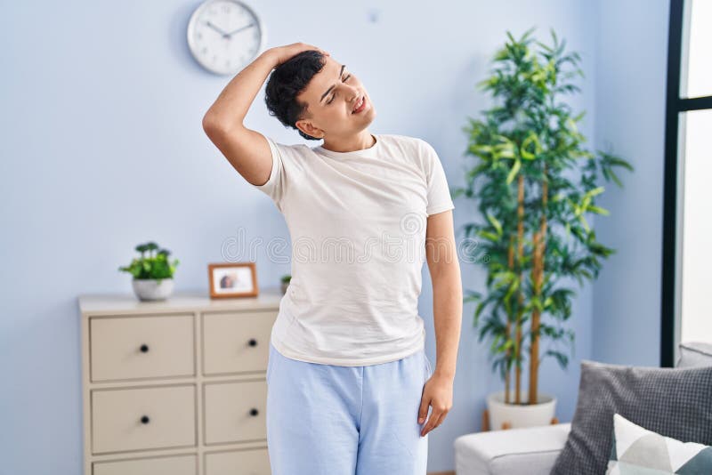 Young Non Binary Man Smiling Confident Stretching Head at Home Stock ...