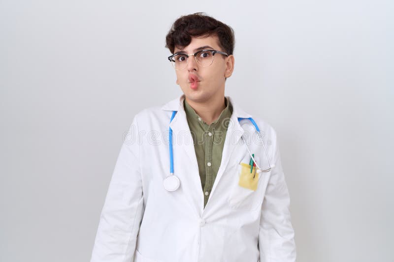 Young Non Binary Man Wearing Doctor Uniform and Stethoscope Making Fish ...