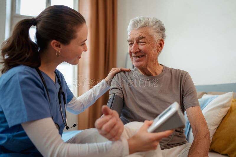 Young Nurse Checking Elderly Senior in His Home. Stock Photo - Image of ...