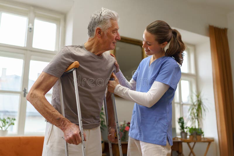 Young Nurse Helping Senior Man with Walking. Stock Image - Image of ...