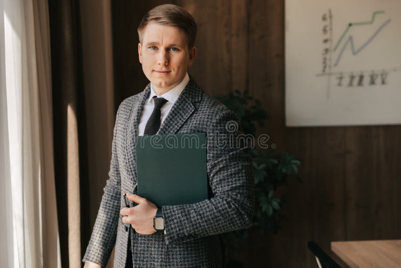 A Young Office Worker with Fair Skin Holds a Folder with Documents in ...