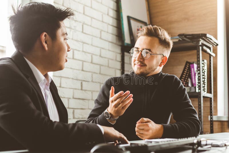 Young Office Worker Sitting at Desk, Using Computer. Two Business Man ...