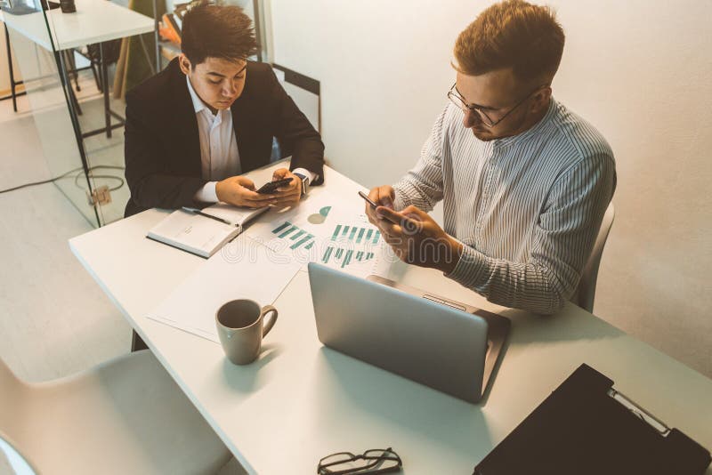 Young Office Worker Sitting at Desk, Using Computer. Two Business Man ...