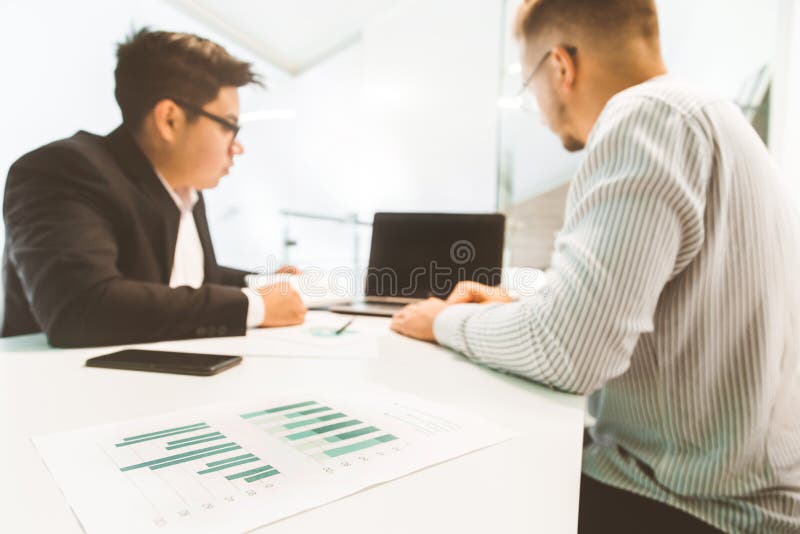 Young Office Worker Sitting at Desk, Using Computer. Two Business Man ...