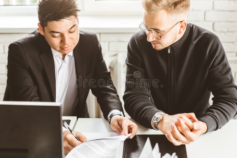 Young Office Worker Sitting at Desk, Using Computer. Two Business Man ...