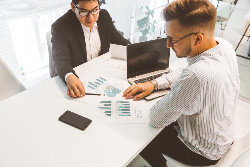 Young Office Worker Sitting at Desk, Using Computer. Two Business Man ...