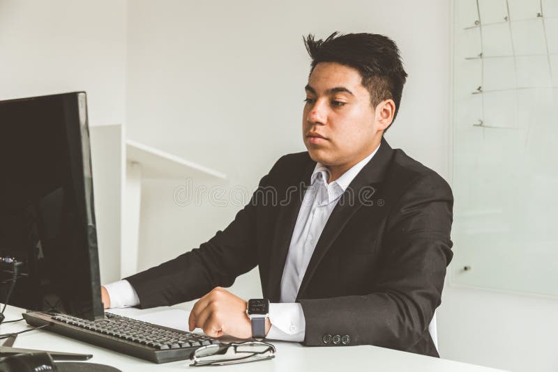 Young Office Worker Sitting at Desk, Using Computer. Two Business Man ...