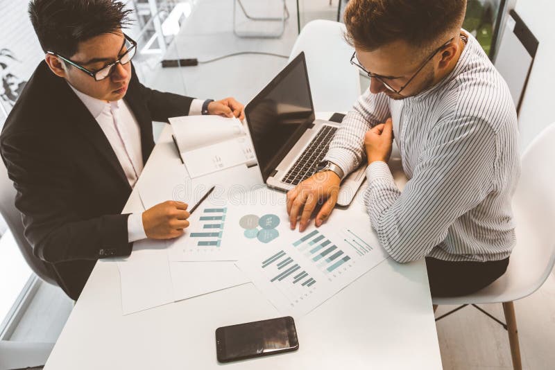 Young Office Worker Sitting at Desk, Using Computer. Two Business Man ...