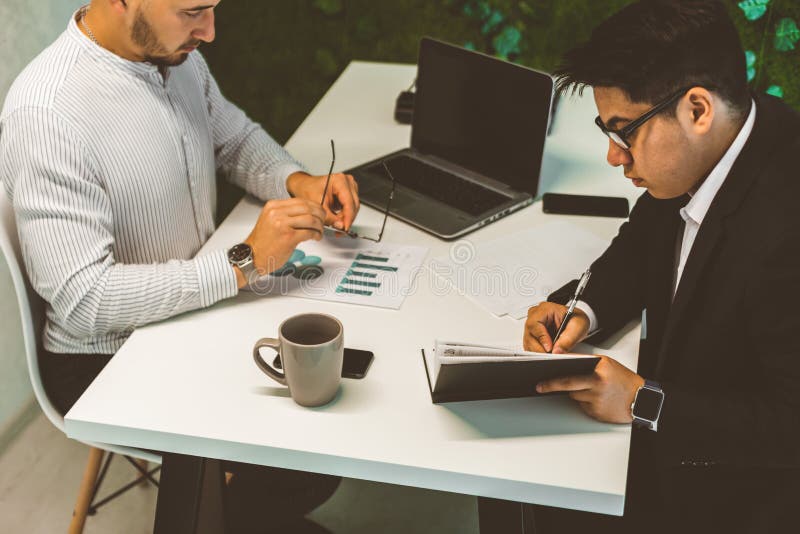 Young Office Worker Sitting at Desk, Using Computer. Two Business Man ...