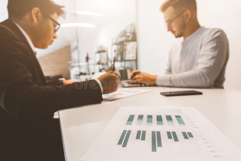 Young Office Worker Sitting at Desk, Using Computer. Two Business Man ...