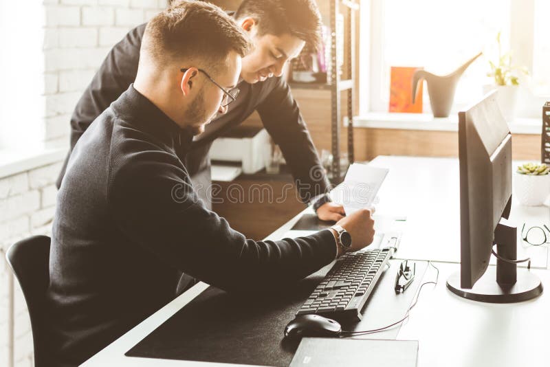 Young Office Worker Sitting at Desk, Using Computer. Two Business Man ...