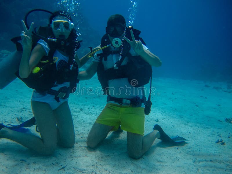 Young Pair on the Seafloor while Diving Stock Photo - Image of holiday ...