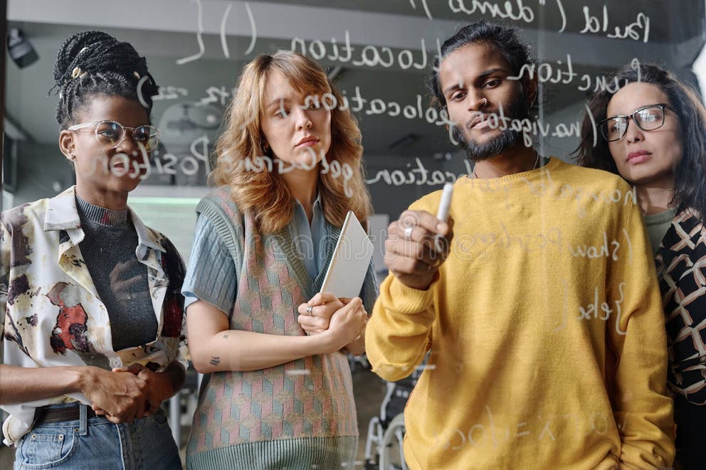 Multi-Ethnic Group of Young Office Workers Writing Code on Glass Wall ...