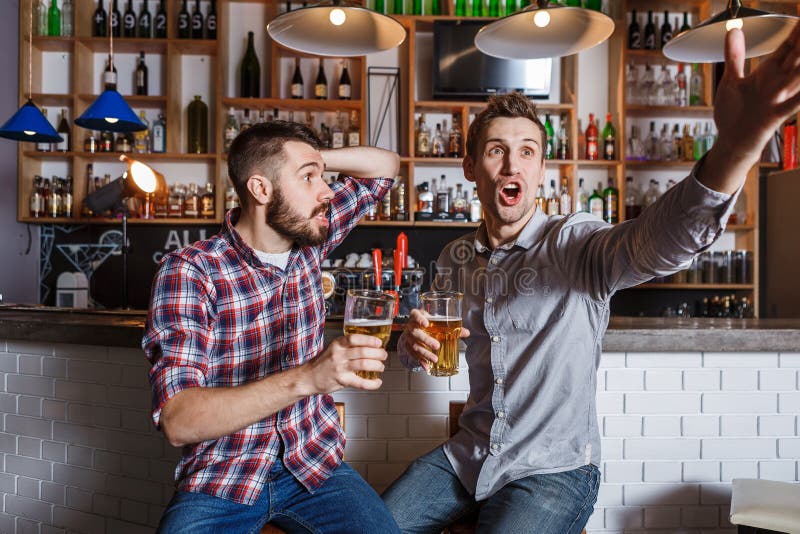 Young People with Beer Watching Football in a Bar Stock Photo - Image ...