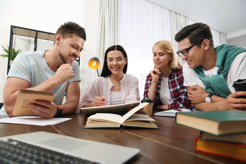 Young People Discussing Group Project at Table in Library Stock Photo ...