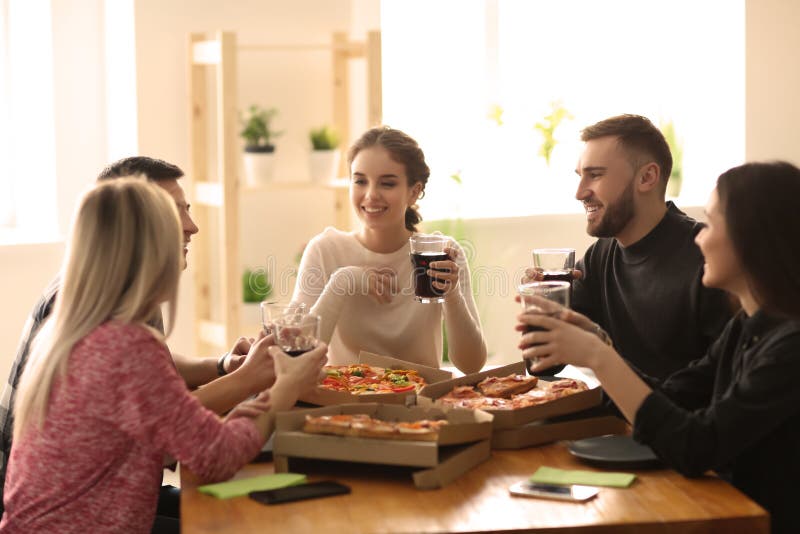 Young People Eating Pizza at Table Indoors Stock Photo - Image of ...