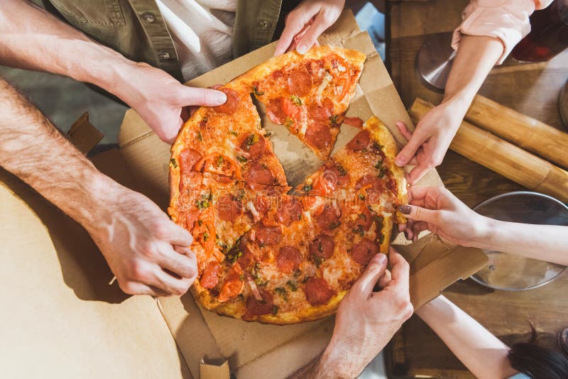 Young people eating pizza stock image. Image of table - 93416549