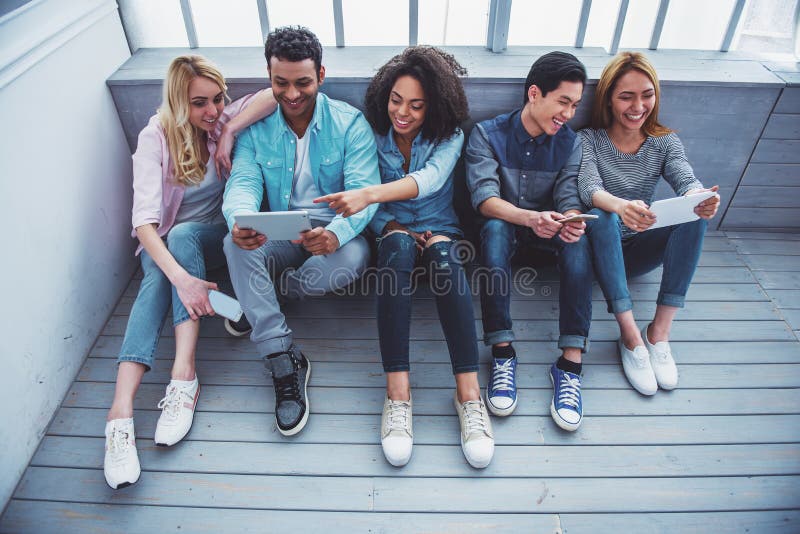 Young people with gadgets stock image. Image of college - 260903115