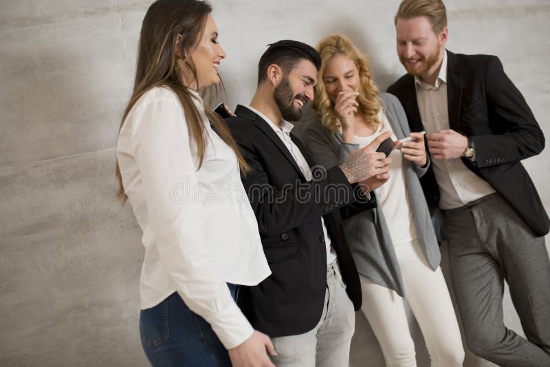 Young People with Mobile Phones Standing by the Grey Wall Stock Image ...