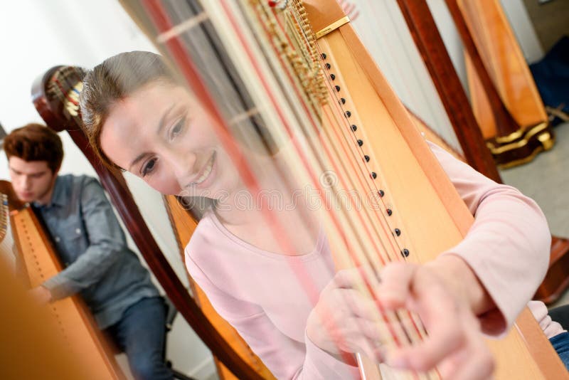 Young people playing harps stock image. Image of harp - 122442519