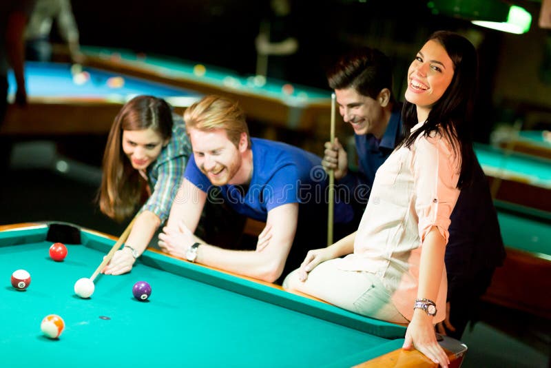 Young people playing pool stock photo. Image of stick - 58289750
