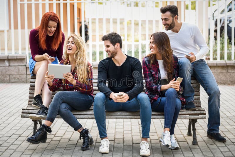 Young People Using Smartphone and Tablet Computers Outdoors Stock Photo ...
