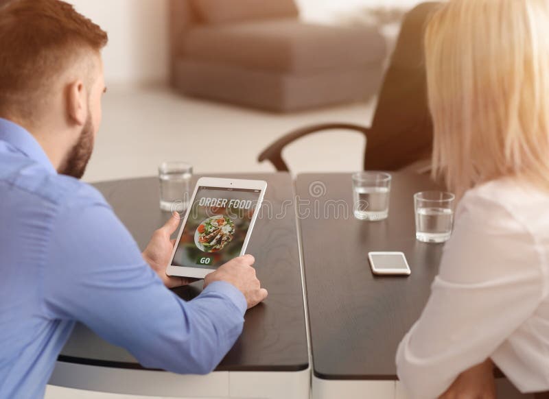 Young People Using Tablet Computer for Ordering Food in Office Stock ...
