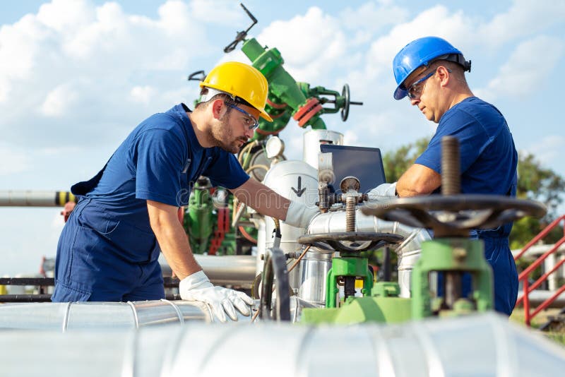 Two Petrochemical Workers Inspecting Pressure Valves on a Fuel Tank ...