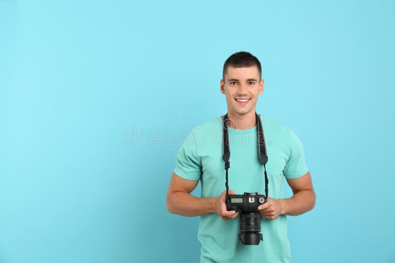 Young Photographer with Camera on Light Blue Background. Space for Text ...