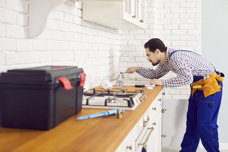Young Plumber Using His Tools To Fix the Problem of the Leaking Tap in ...