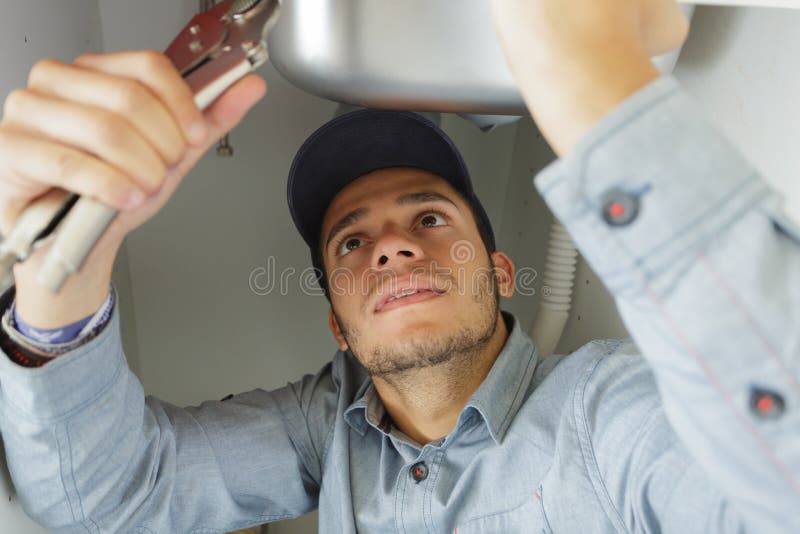 Young Plumber Using Wrench Under Sink Stock Photo - Image of handyman ...