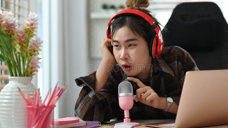 Young Podcaster Using a Microphone and Laptop Computer Recording Audio ...