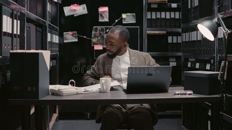 Young Policeman Examining Forensic Evidence in Office Stock Photo ...
