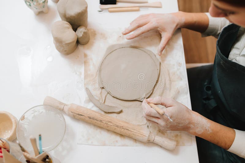 Young Potter Cuts a Circle of Clay with Pottery Tool in the Workshop ...