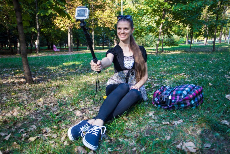 Young Pretty Girl Sitting on Grass and Taking Selfie on an Action ...