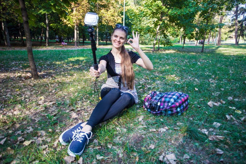 Young Pretty Girl Sitting on Grass and Taking Selfie on an Action ...