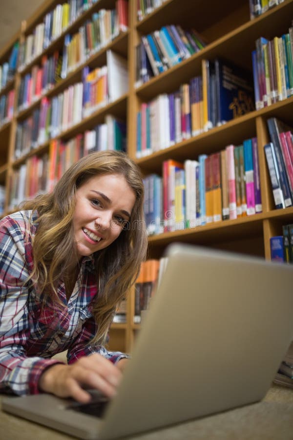 Young Pretty Student Lying on Library Floor Using Laptop Stock Photo ...