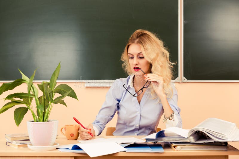 Young Pretty Teacher Checking the Tests. Stock Photo - Image of reading ...