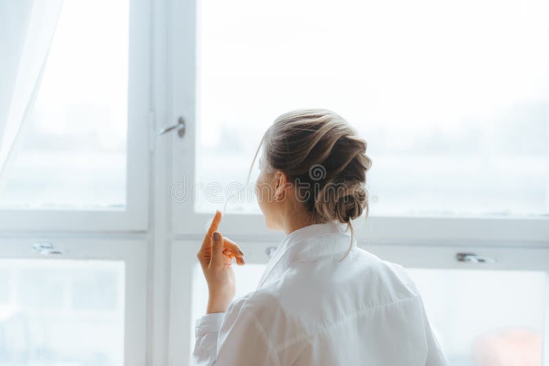 Young Pretty Woman Standing by a Window Looking Outside Expecting ...