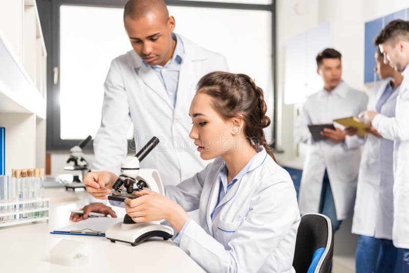 Professional Chemists in White Coats Working with Microscopes in ...
