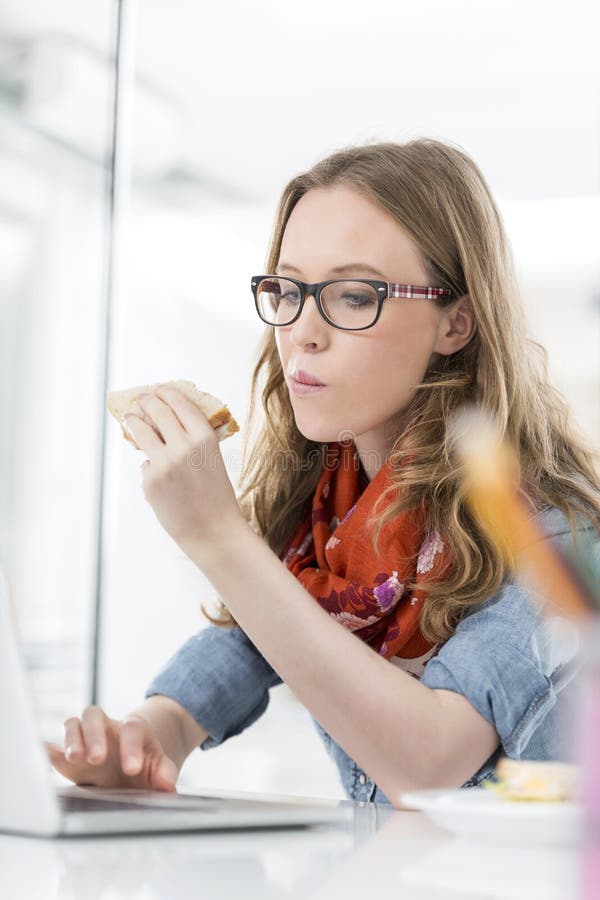 Young Professional Eating Snack at Desk in Office Stock Photo - Image ...