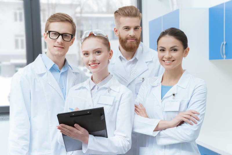 Young Professional Scientists in Lab Coats Smiling at Camera Stock ...