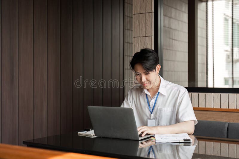 Young Professional Typing on Laptop in Modern Office, Demonstrating ...