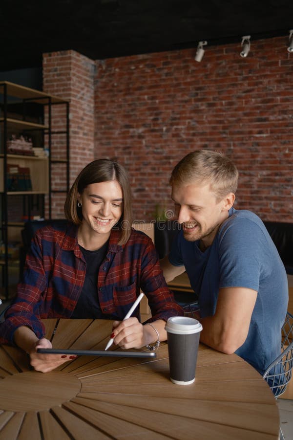 Young Professionals Collaborating with a Tablet in a Cozy Modern ...